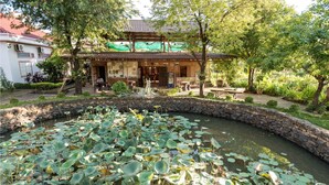 Um edifício tradicional japonês com um lago em primeiro plano.