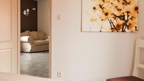 Um quarto com cama, uma cadeira e um quadro na parede.