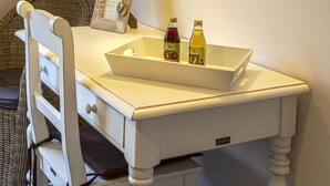Uma mesa branca com um suporte, duas garrafas e uma moldura.