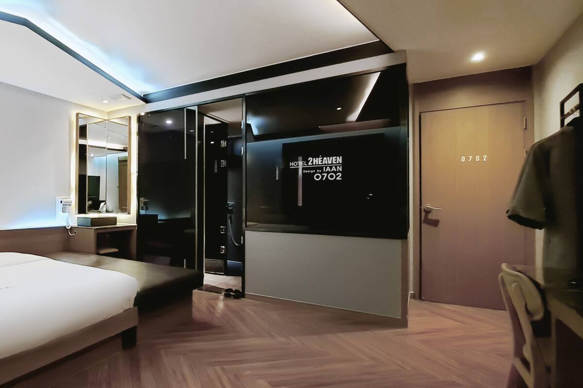 Quarto de hotel moderno com uma cama grande, uma escrivaninha e um guarda-roupa.