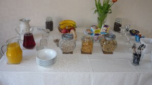 Disposição de buffet de café da manhã com diversos alimentos e bebidas.