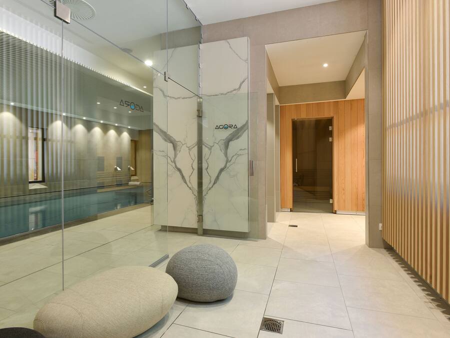 Um hall moderno com paredes de vidro, um design de árvore em mármore e áreas de estar.