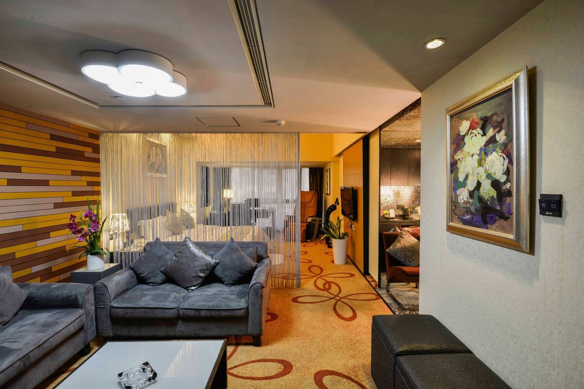 Uma sala de estar moderna com sofá, mesa de centro e um quadro na parede.