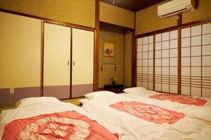 Um quarto em estilo tradicional japonês, com tatames, uma porta deslizante e um painel shoji.