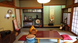 Um quarto japonês tradicional com tatames, uma mesa de madeira baixa e um painel shoji.