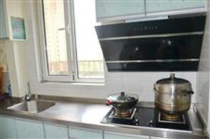 Apartamento, 2 quartos | Cozinha americana privada | Geladeira grande, micro-ondas (mediante solicitação), cooktop