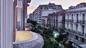Varanda com design curvo com vista para a paisagem urbana ao pôr do sol.