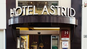 Entrada de hotel com uma placa que diz "HOTEL ASTRID".
