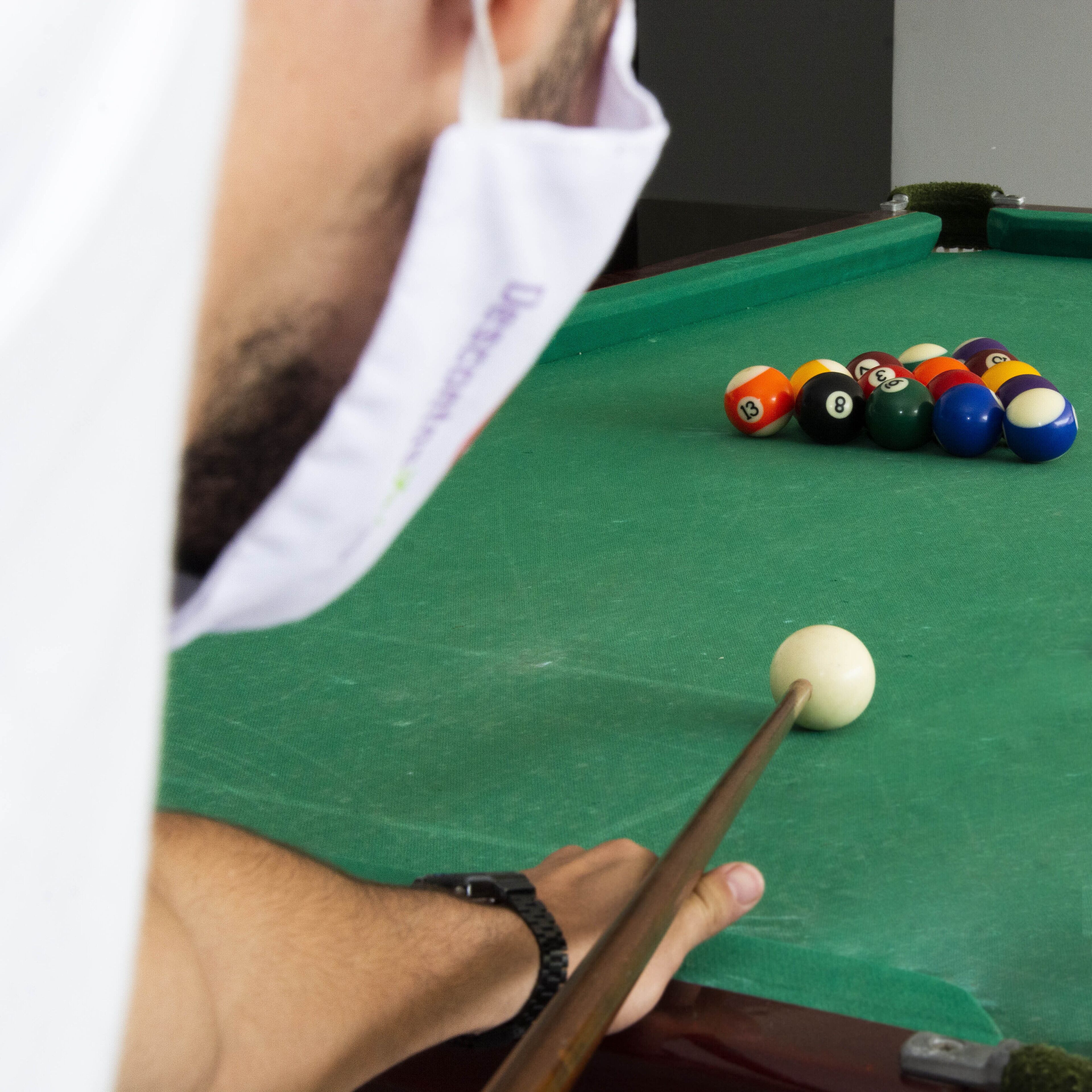 Uma mesa de bilhar com bola vermelha e bolas numeradas.