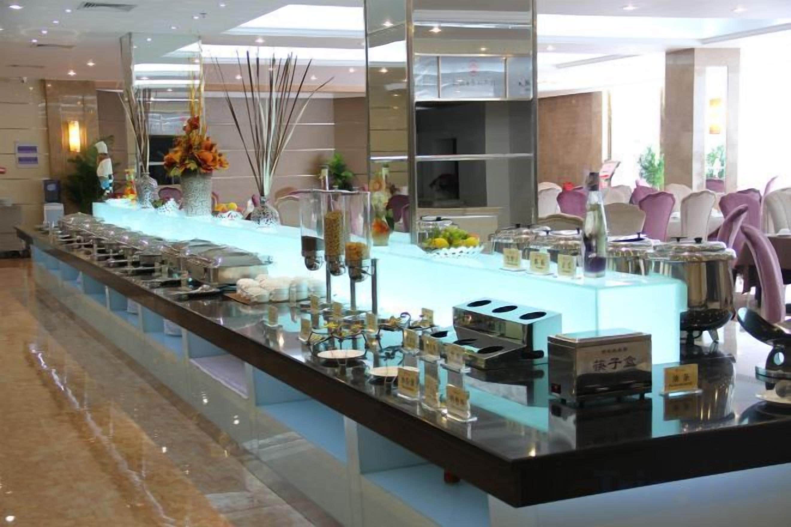 Disposição de buffet com diversas estações de comida e um balcão comprido.
