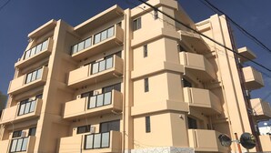 Um edifício de vários andares com varandas, um letreiro com 