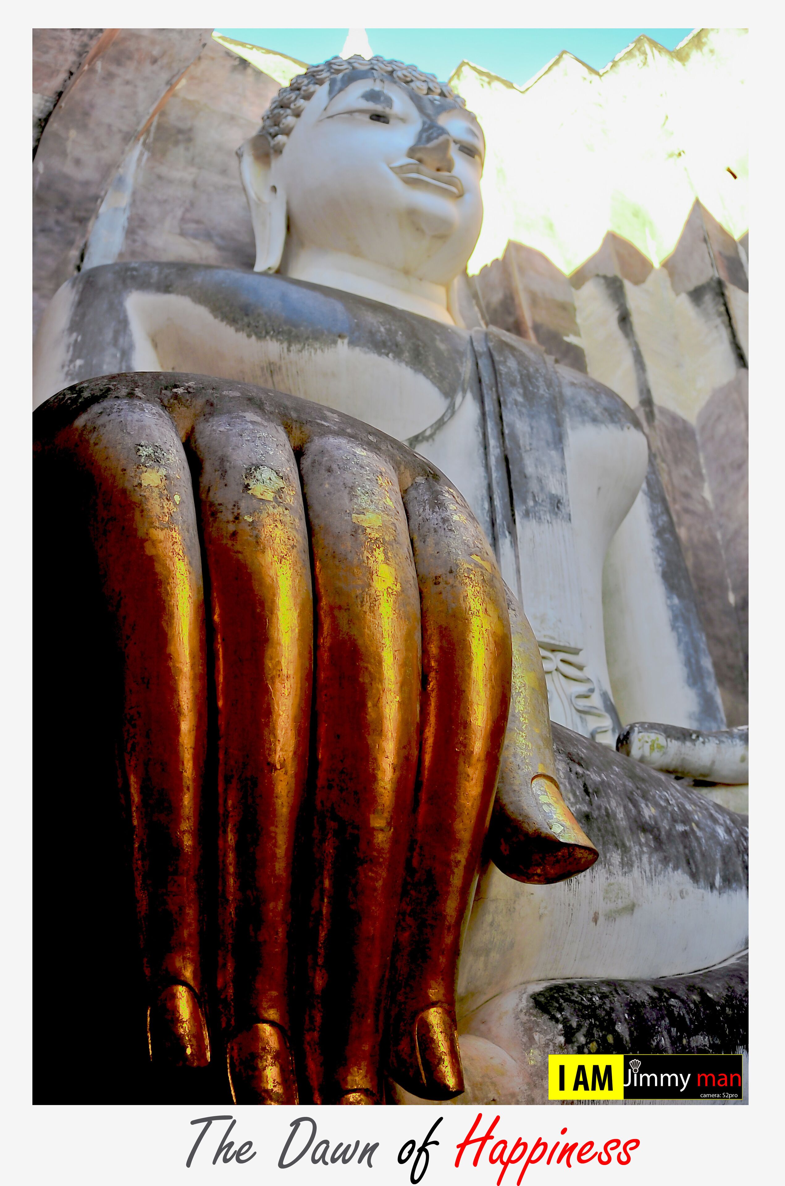 Uma grande estátua de Buda com uma mão dourada.