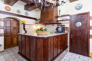 Uma cozinha com armários de madeira, uma ilha central com um cesto de flores e uma cafeteira.