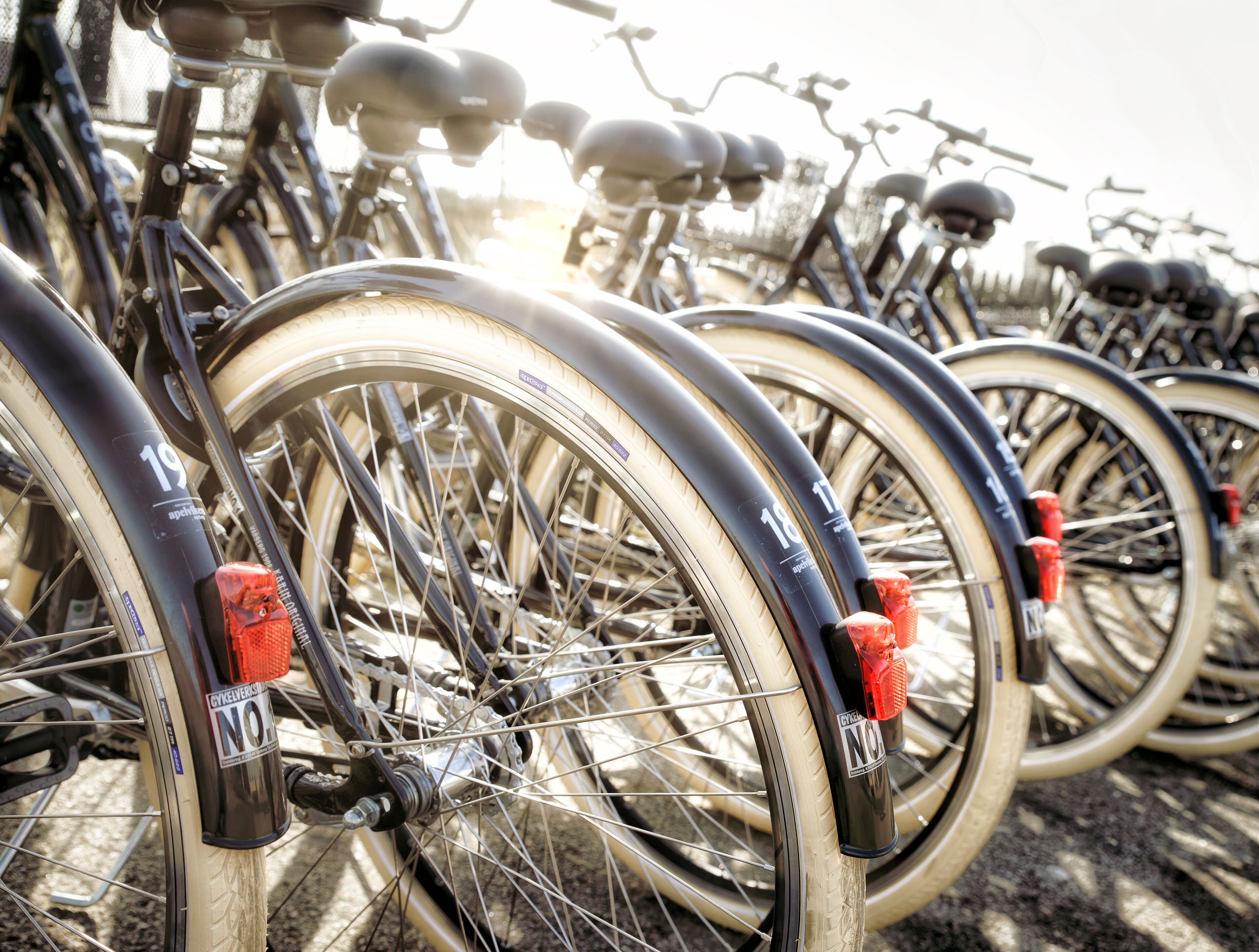 Várias bicicletas estacionadas juntas em fila.
