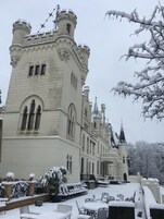 Um edifício com estilo de castelo, com várias torres e janelas em arco.