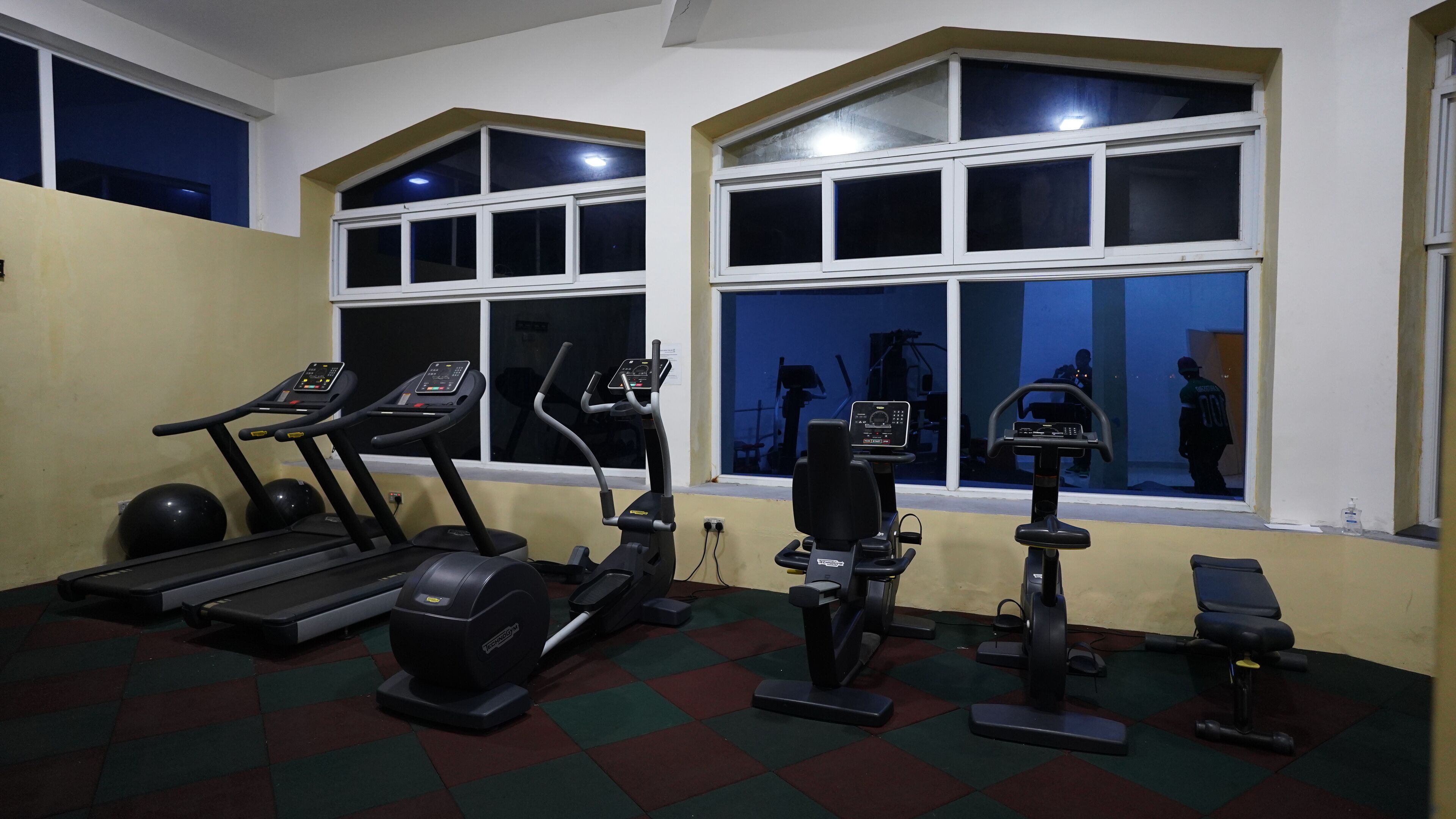 Uma academia com esteiras, elípticos e equipamentos de musculação.