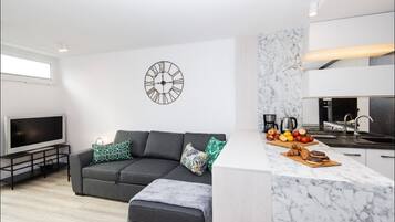 Apartamento, 2 quartos | Sala de estar | TV de ecrã plano