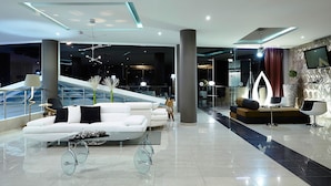 Um lobby moderno com um sofá branco, uma mesa de centro de vidro e um design de bicicleta exclusivo.