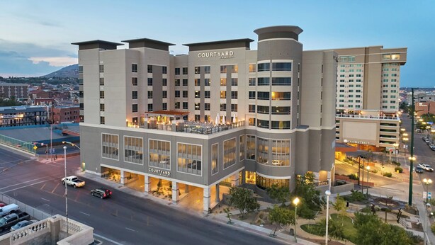Um hotel Courtyard by Marriott com design moderno, vários andares e estacionamento.