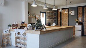 Uma cozinha moderna com uma ilha de madeira, luminárias pendentes e uma pequena árvore de Natal.