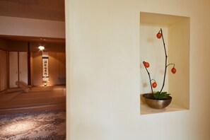 Um quarto japonês tradicional, com piso de tatame, uma mesa baixa e um conjunto de chá, e um biombô shoji.