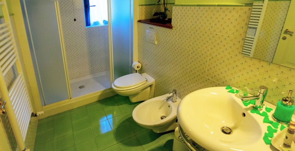 Uma casa de banho com sanita, bidé e lavatório.