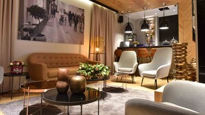 Uma sala de estar moderna com um sofá, duas poltronas, uma mesa de centro e um espaço de jantar com balcão.