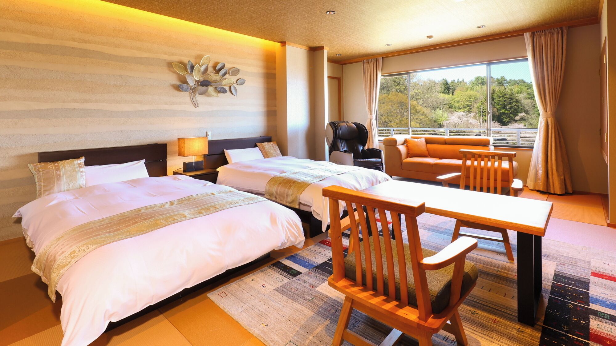Quarto de hotel com duas camas, uma cadeira de massagem, um sofá e uma mesa de jantar.