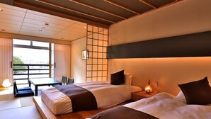 Quarto de hotel com duas camas, uma escrivaninha e vista para o exterior.