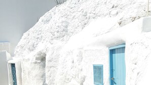 Um edifício branco com uma porta azul e uma pequena janela.