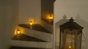 Uma escadaria com três lanternas iluminadas em cada degrau e uma única lanterna no patamar.