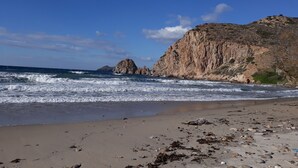 Uma praia com falésias rochosas e ondas.