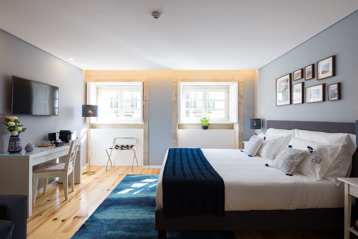 Quarto moderno com cama, escrivaninha e televisão.