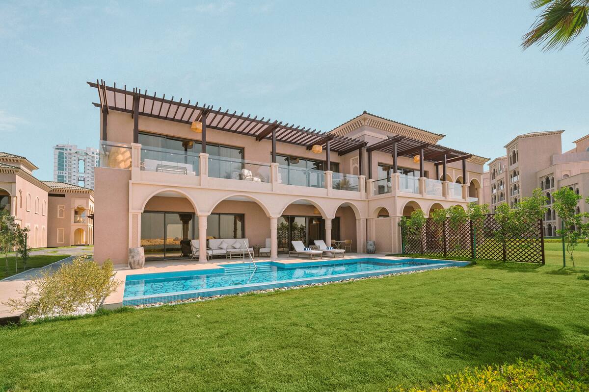 Um hotel moderno com piscina, área de estar externa e alpendre coberto.