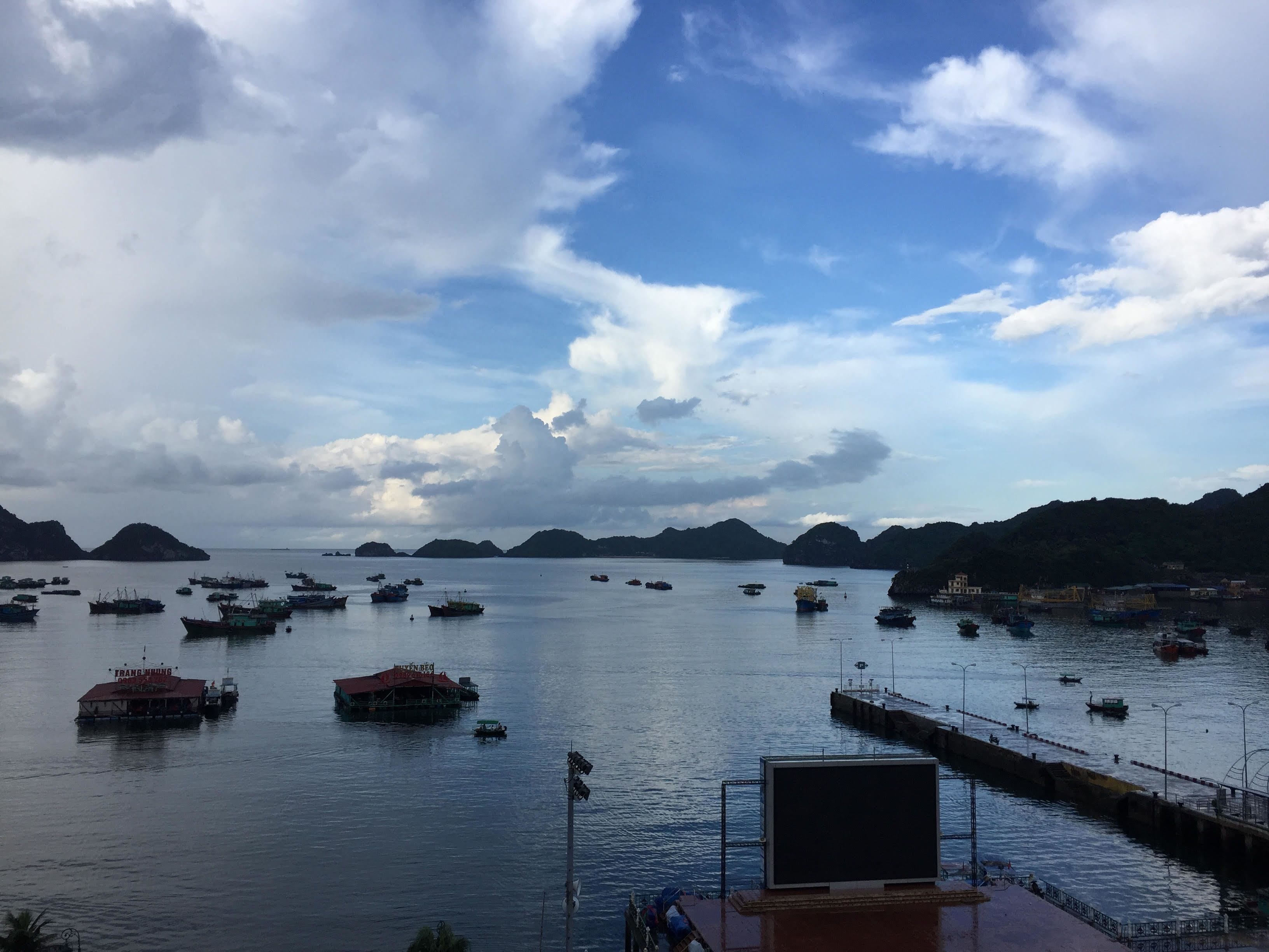 Um porto com vários barcos e um cais.