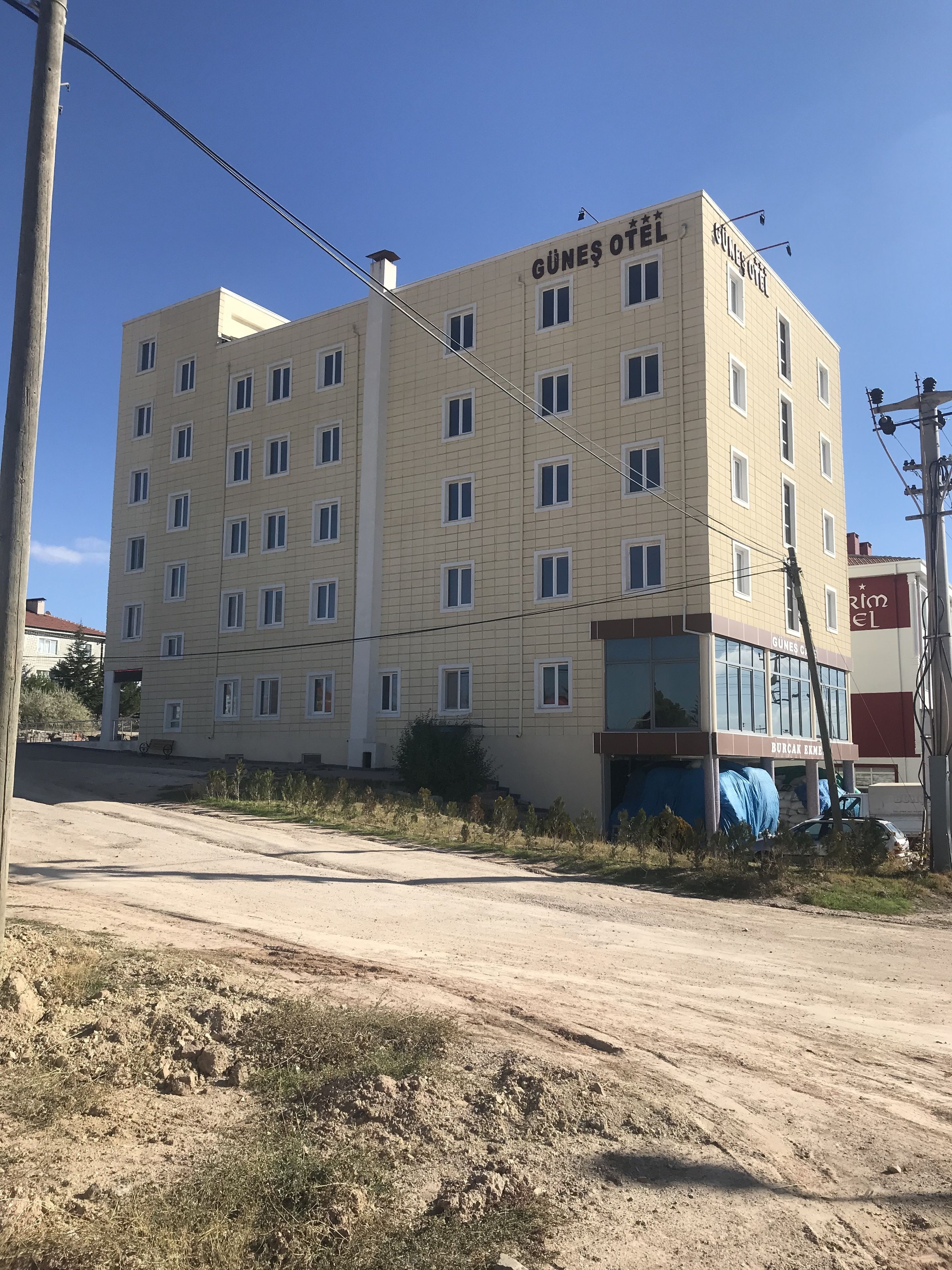 Hotel com vários andares, fachada bege e diversas janelas.