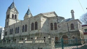 Um edifício histórico com uma torre de sino imponente e janelas em arco.
