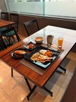 Uma mesa de jantar com dois pratos de comida, uma tigela, uma xícara e um copo de suco de laranja.