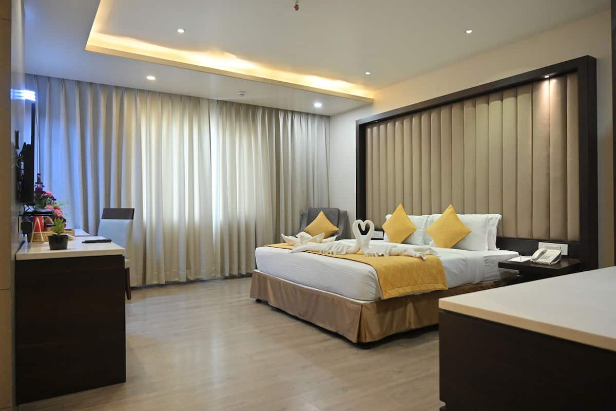 Quarto de hotel moderno com uma cama grande, uma escrivaninha e uma cadeira.