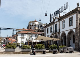Um edifício histórico com uma placa indicando "SANDERMAN" e um teleférico ao fundo.