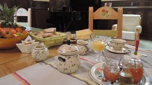 Cenário de café da manhã com um piano ao fundo, uma fruteira e diversos itens para o café da manhã sobre uma mesa.