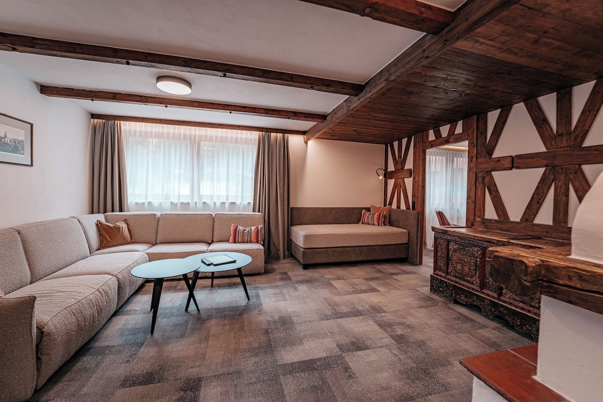 Uma sala de estar com sofá, mesa de centro e um aparador de madeira.