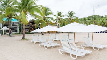 Perto da praia, espreguiçadeiras, guarda-sóis, toalhas de praia