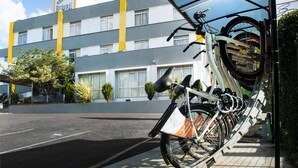 Hotel com suporte para bicicletas e uma bicicleta estacionada na frente.