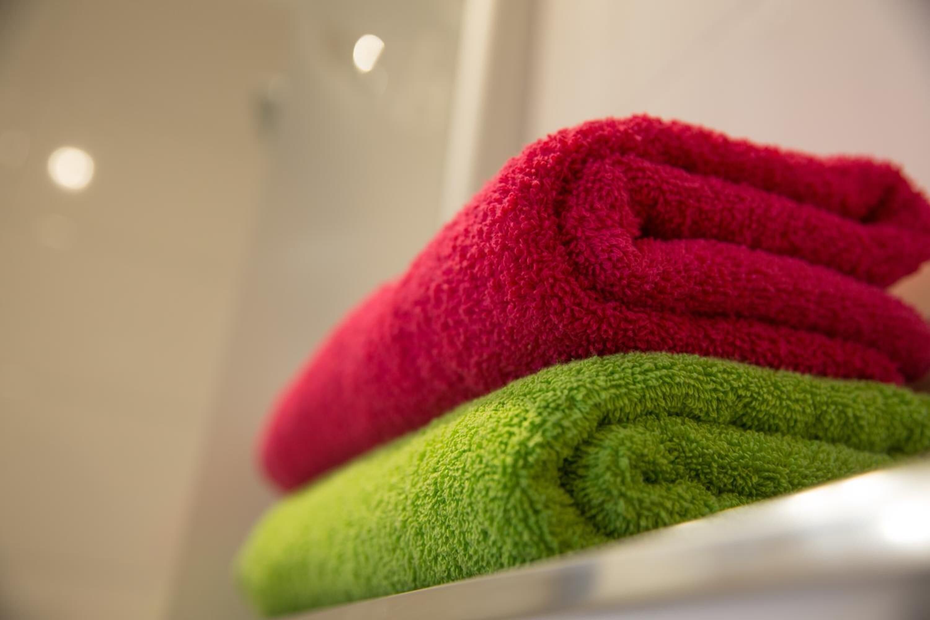 Uma pilha de toalhas dobradas, em tons de vermelho e verde.