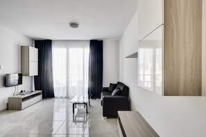 Uma sala de estar moderna com televisão de tela plana, sofá, mesa de centro e armário de madeira.