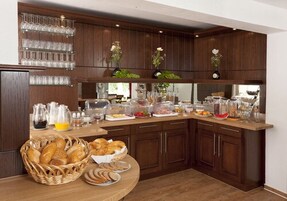 Disposição de buffet de café da manhã com diversos alimentos e bebidas.