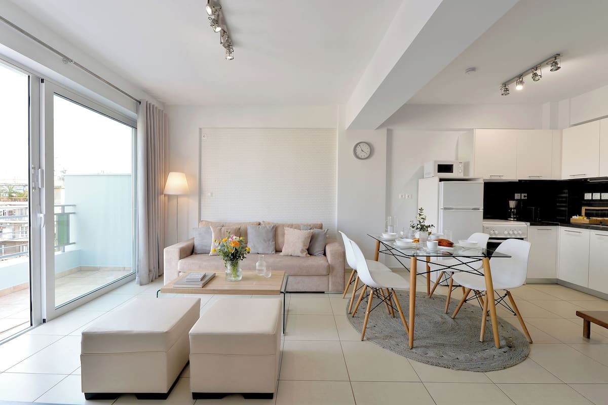 Um apartamento moderno com sala de estar, espaço para refeições e cozinha.