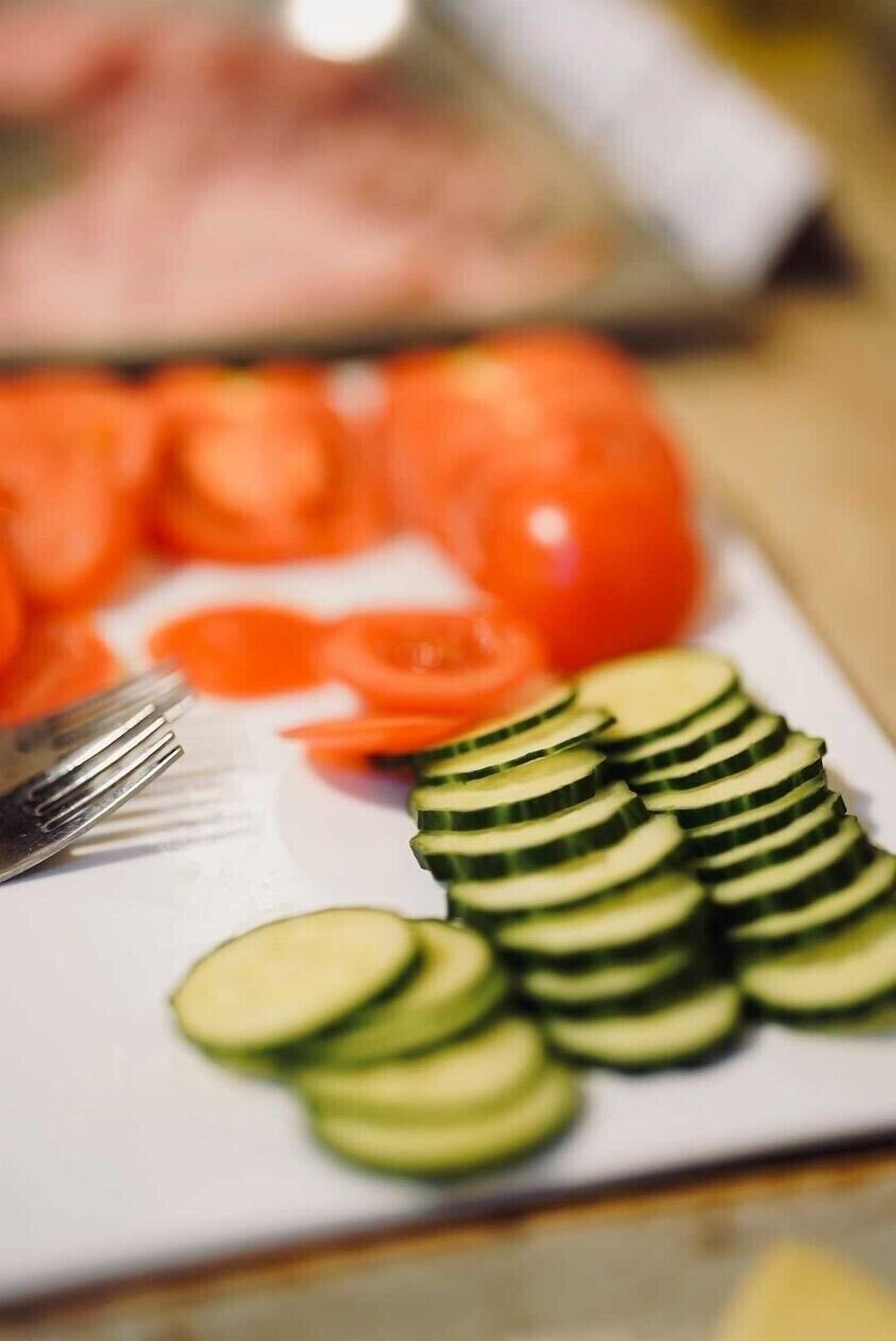 Um prato com pepino e tomate fatiados.