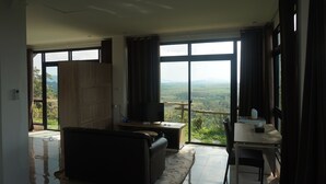 Uma sala de estar espaçosa com uma ampla porta de vidro que se abre para uma varanda com vista panorâmica.